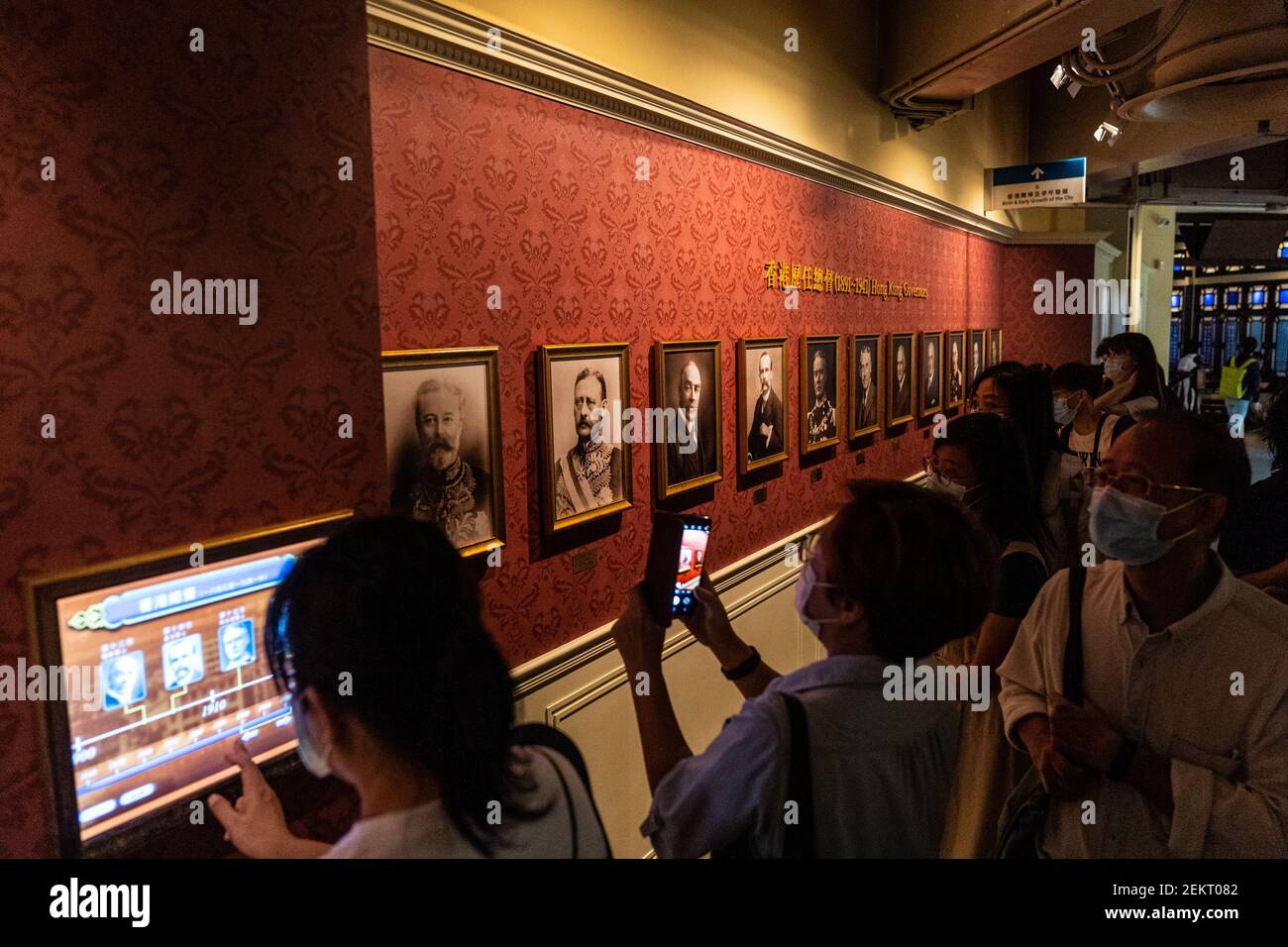A visitor taking pictures of portraits of Hong Kong Governors at the ...