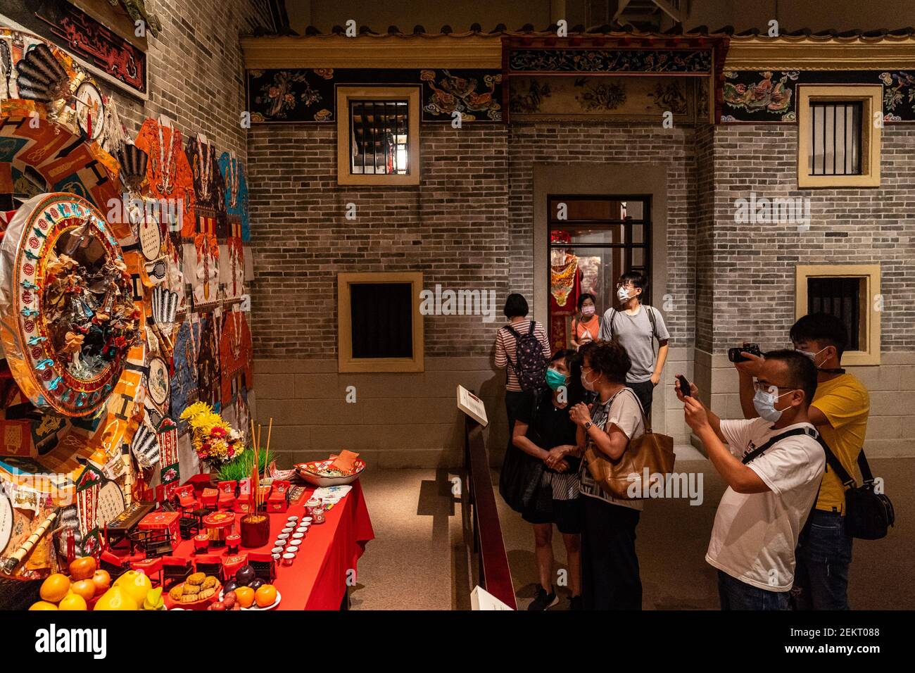 Visitors wearing face masks taking pictures of an exhibit. The â€œHong ...