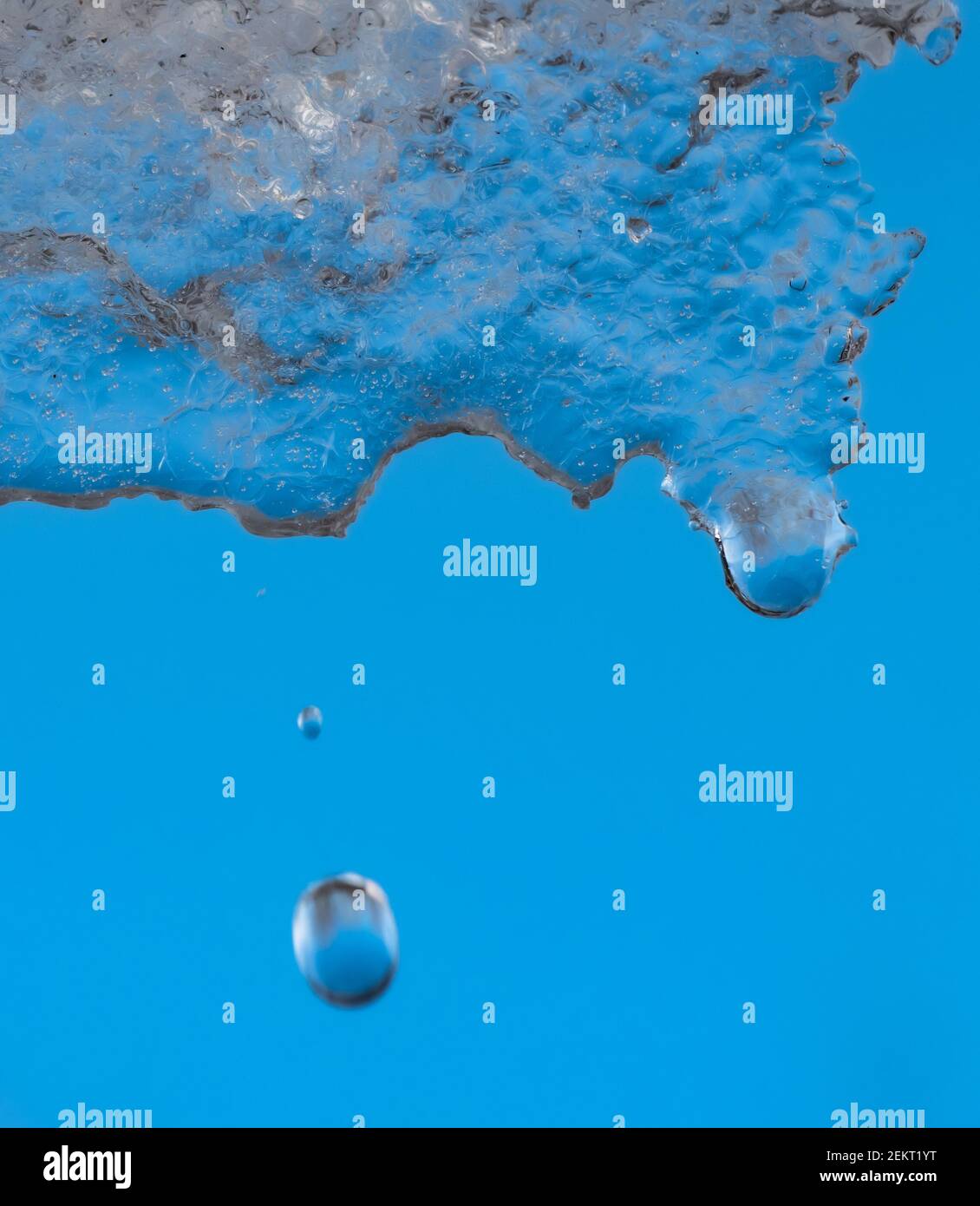 Abstract image of textured melting ice with water droplets falling on a ...