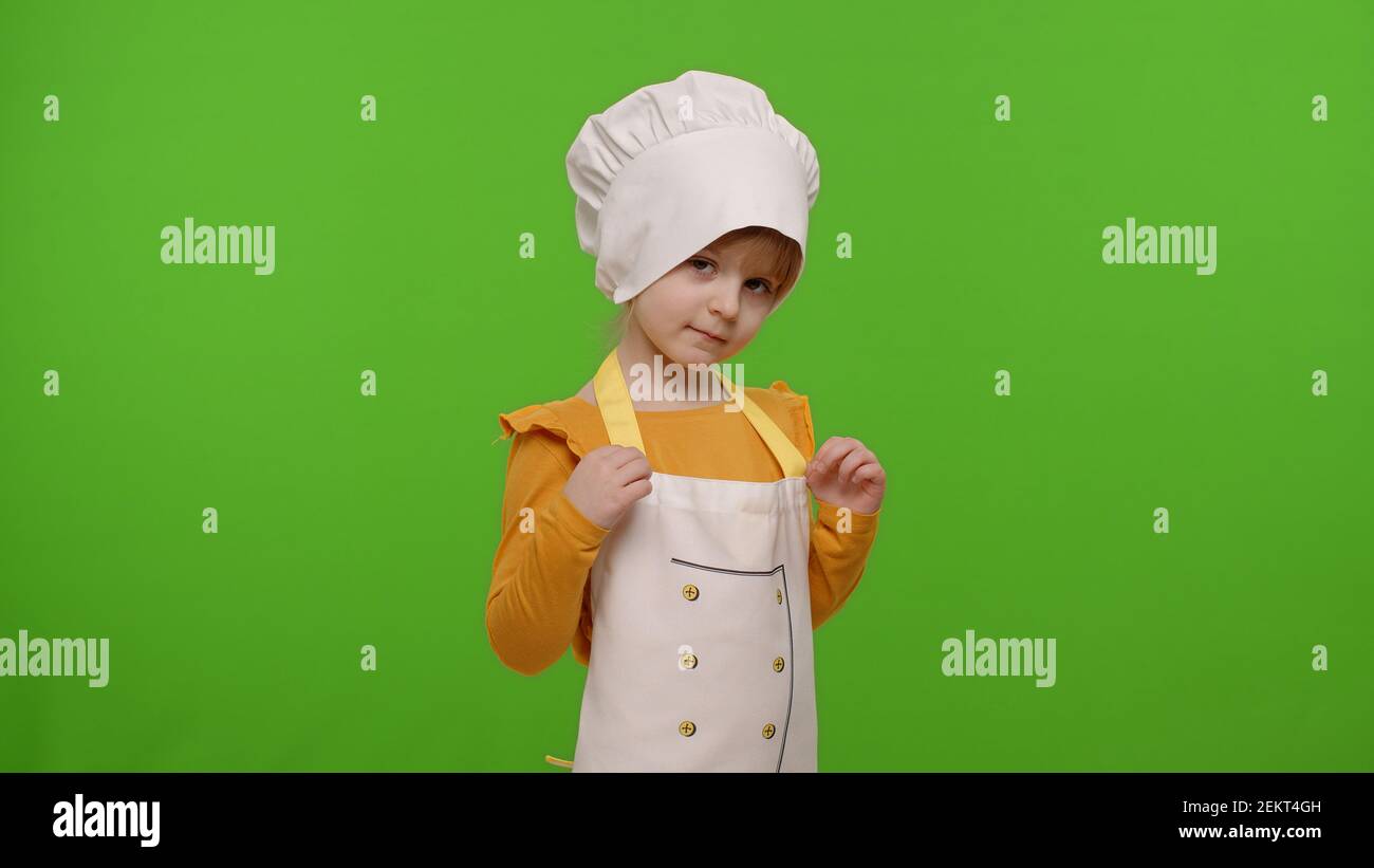 Child girl kid dressed as professional cook chef smiling, looking at ...