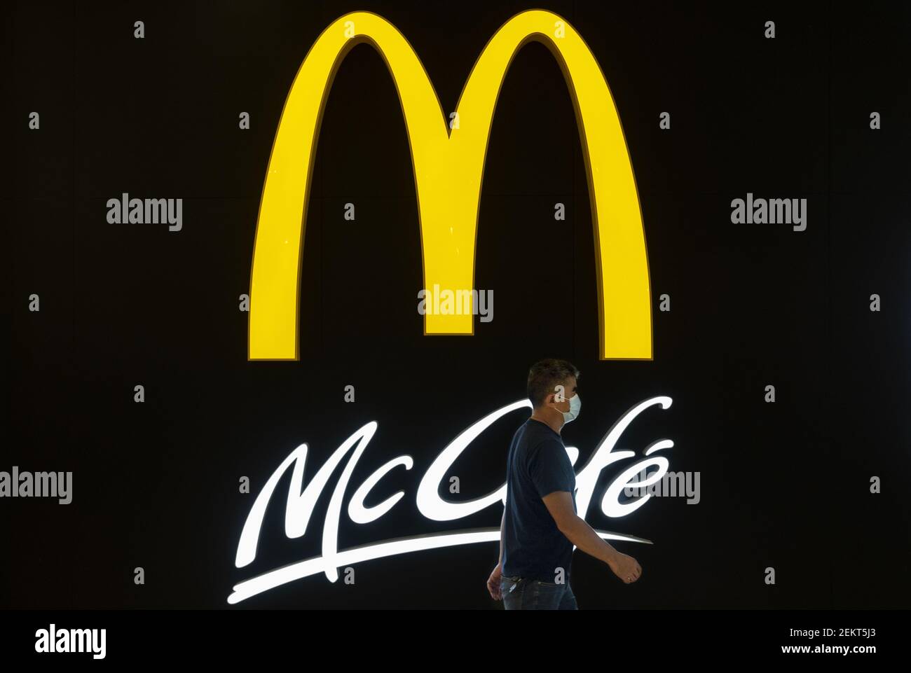 A pedestrian wearing face mask walks past the American multinational ...