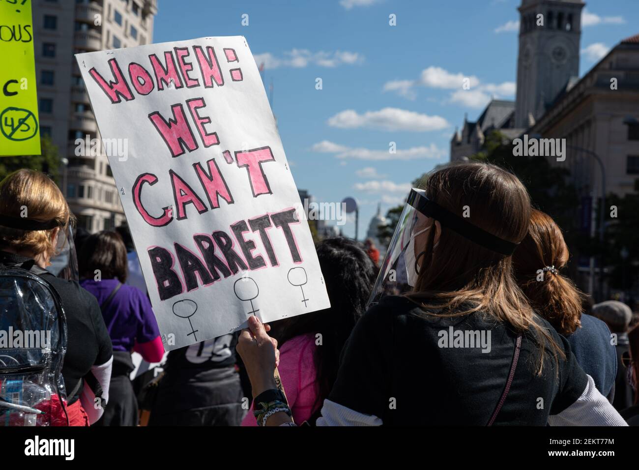 A protester wears a face shield while attending a Women's March rally ...