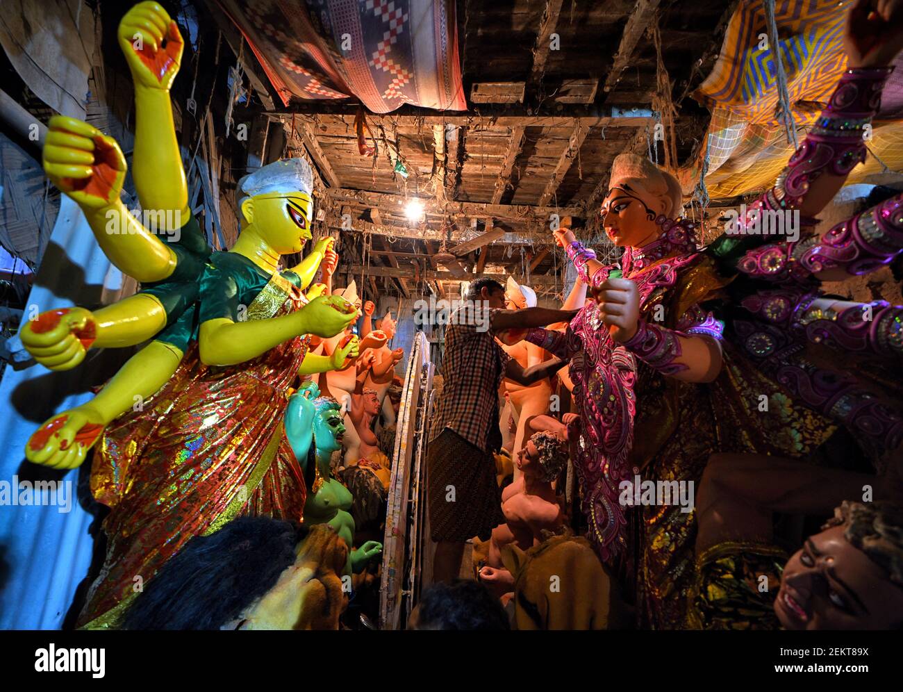 An artist seen giving a final touch on an idol of Hindu God Devi Durga ...