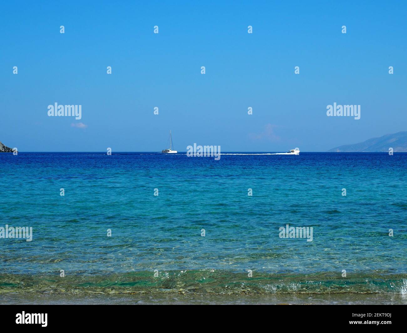 Distant boats on horizon in the clear blue Aegean Sea, Serifos island ...
