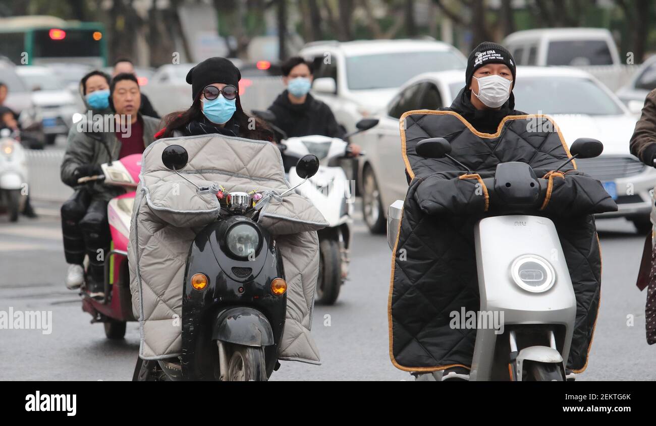 People wear thick clothes and hats while riding on the road because of ...