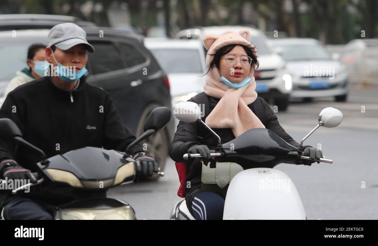 People wear thick clothes and hats while riding on the road because of ...