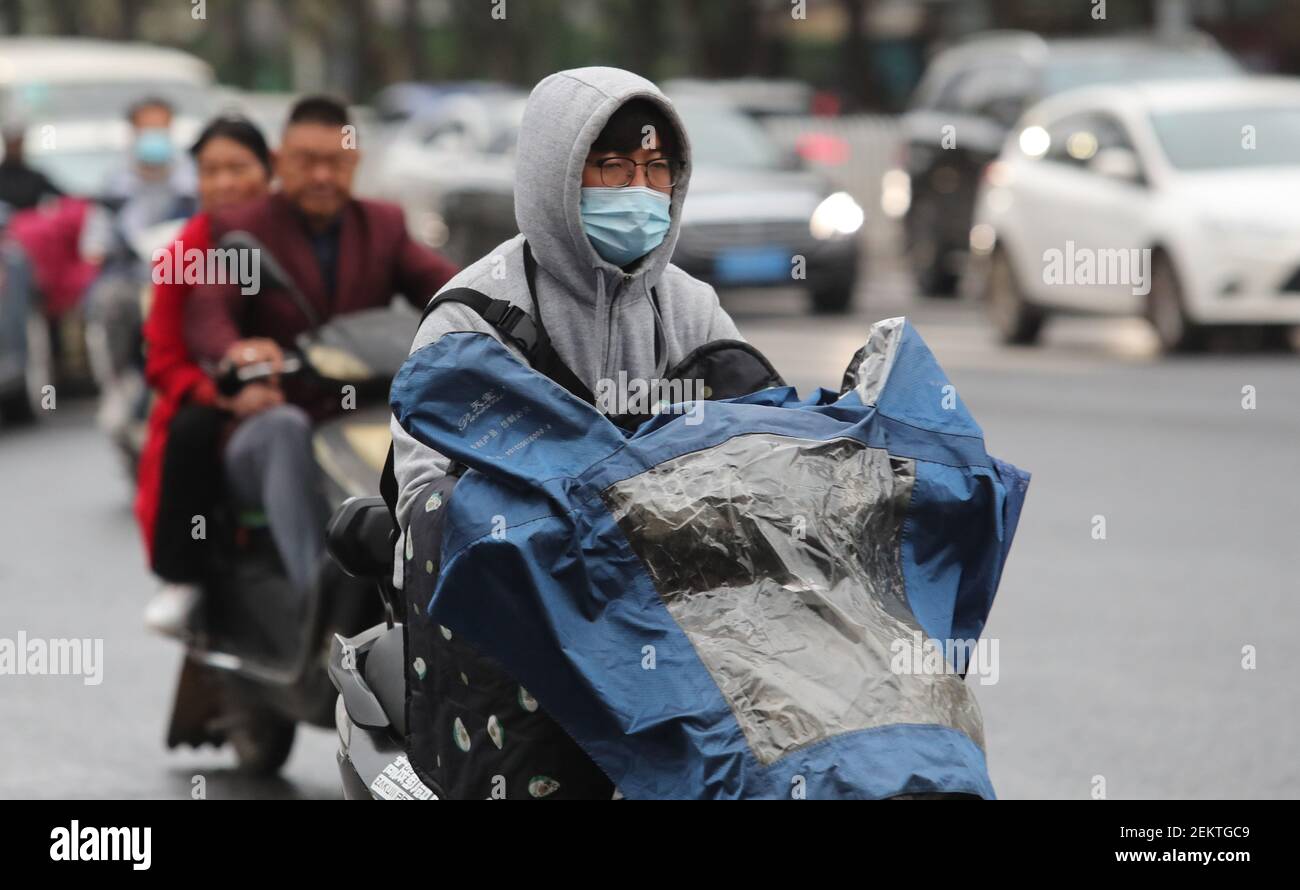 People wear thick clothes and hats while riding on the road because of ...
