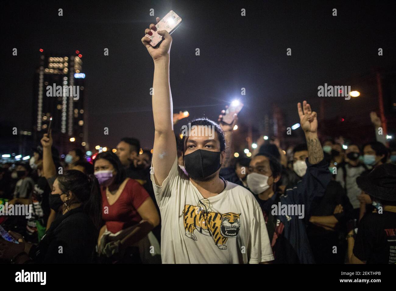 A pro-democracy protester seen holding his phone with the flashlight on ...