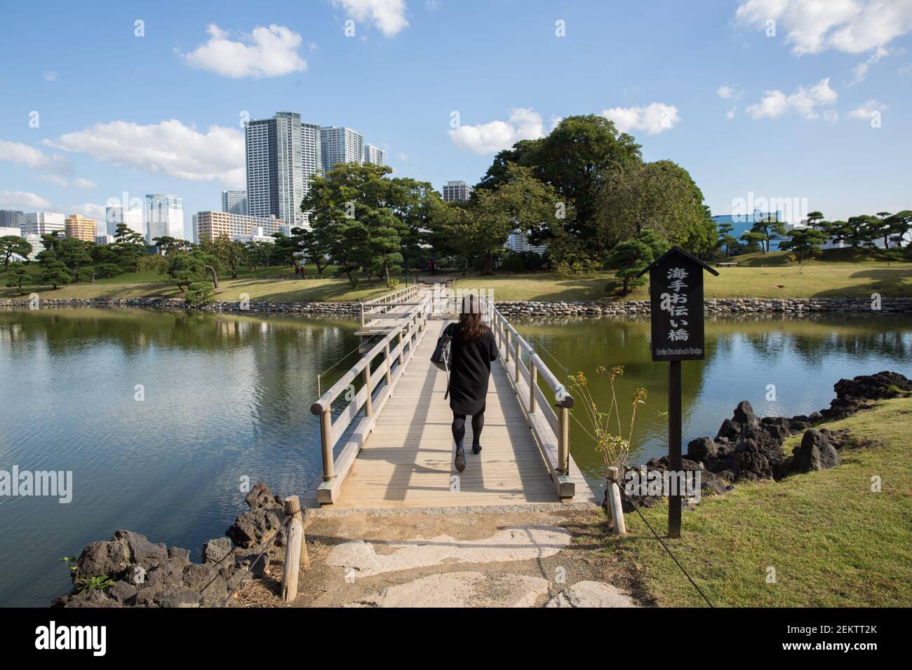 Visitor of Hama-Rikyu Gardens in Tokyo walks over the Umite ...