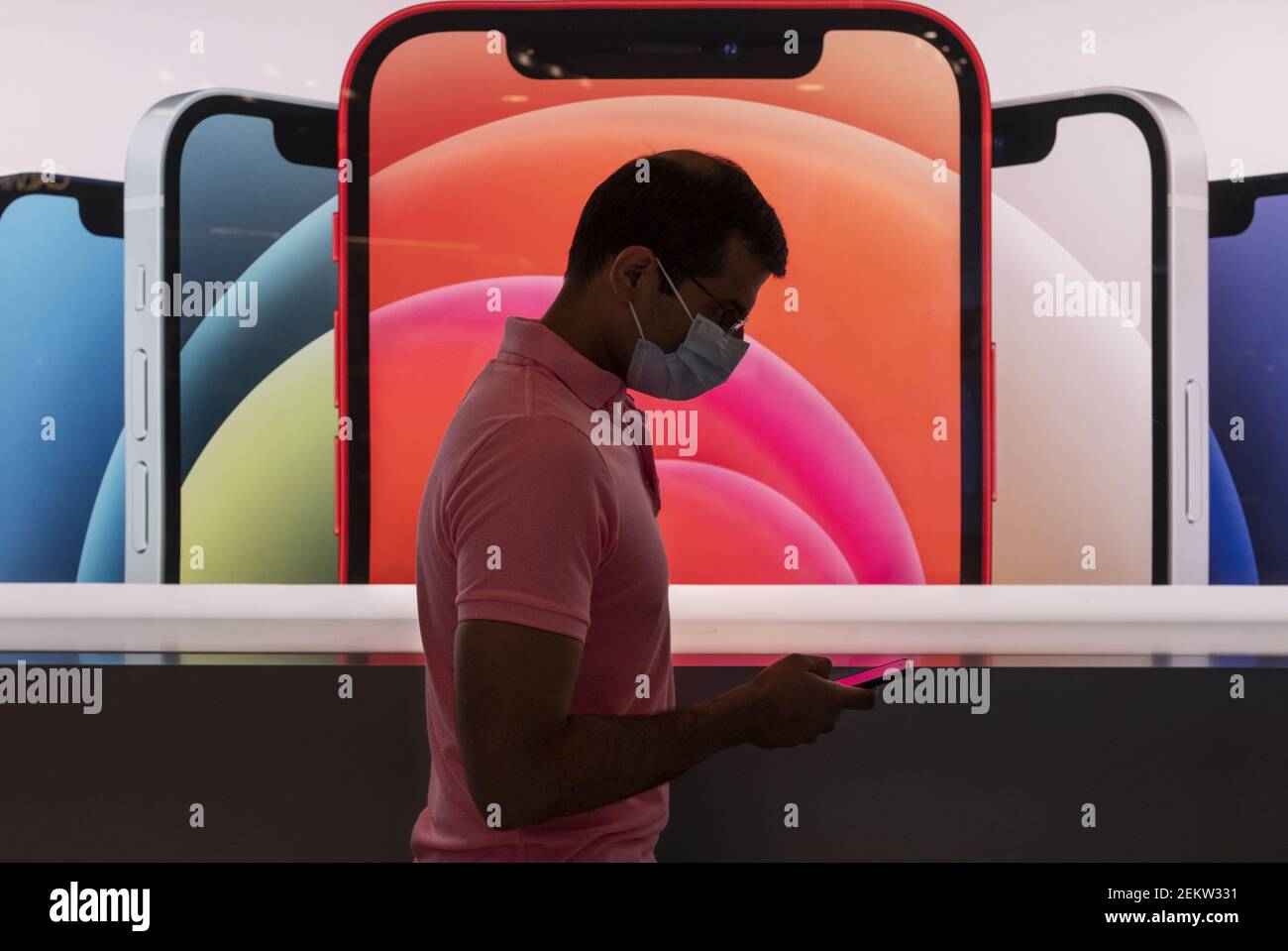 A customer queues in line at an Apple store during the launch day of ...