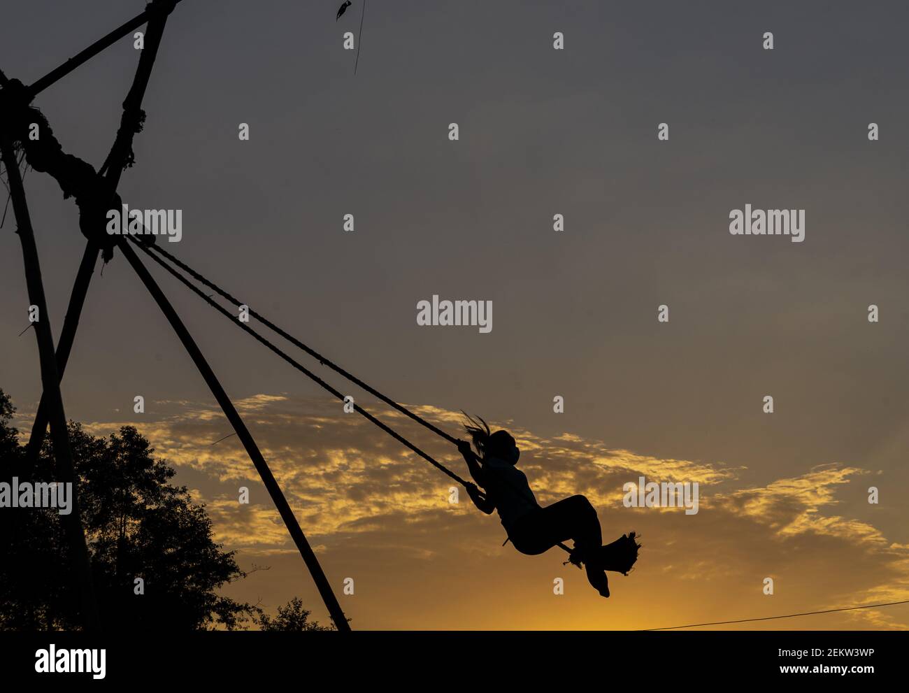 A girl plays on a traditional swing locally known as ping during the ...