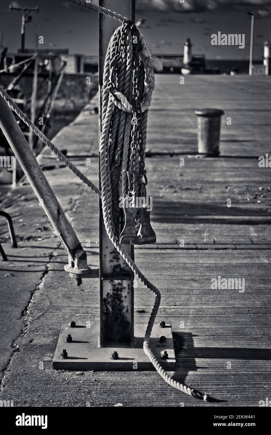 mooring rope tied to an old harbour post, rusted, bolted down, port ...