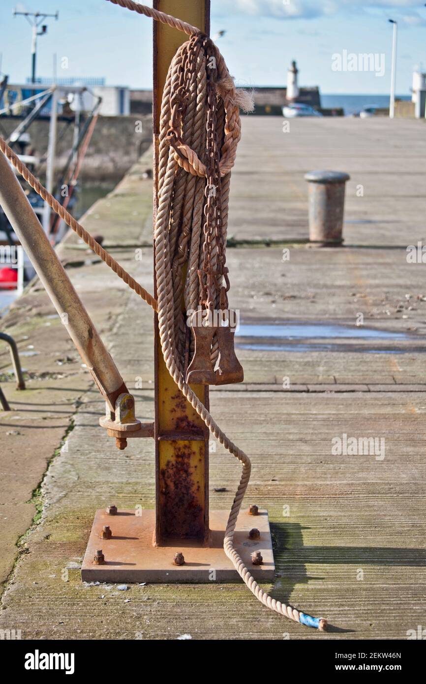 mooring rope tied to an old harbour post, rusted, bolted down, port ...