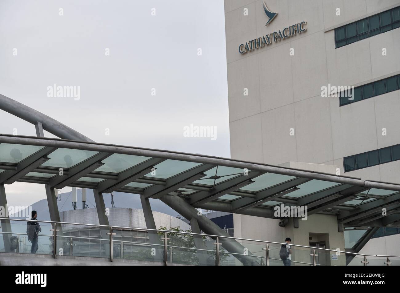 People walking through a pedestrian bridge at the Cathay Pacific City ...