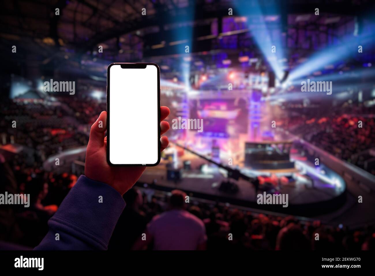 Gamer using smartphone during big esports gaming event sitting on the ...