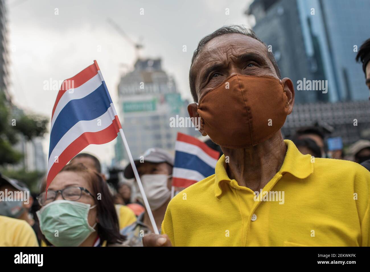 A pro-monarchy protester hold a Thailand flag while listening to a ...