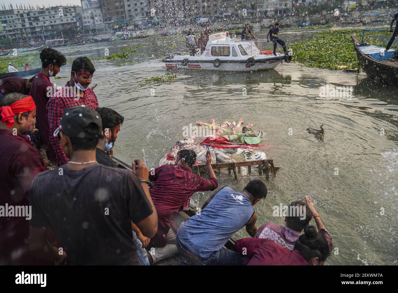 Hindu devotees watch the immersion of the idol of the Hindu goddess ...