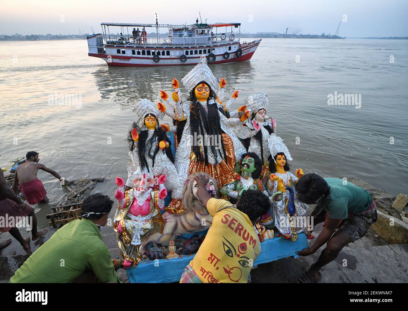 Hindu devotees submerge a clay idol of the Hindu goddess Durga in the ...
