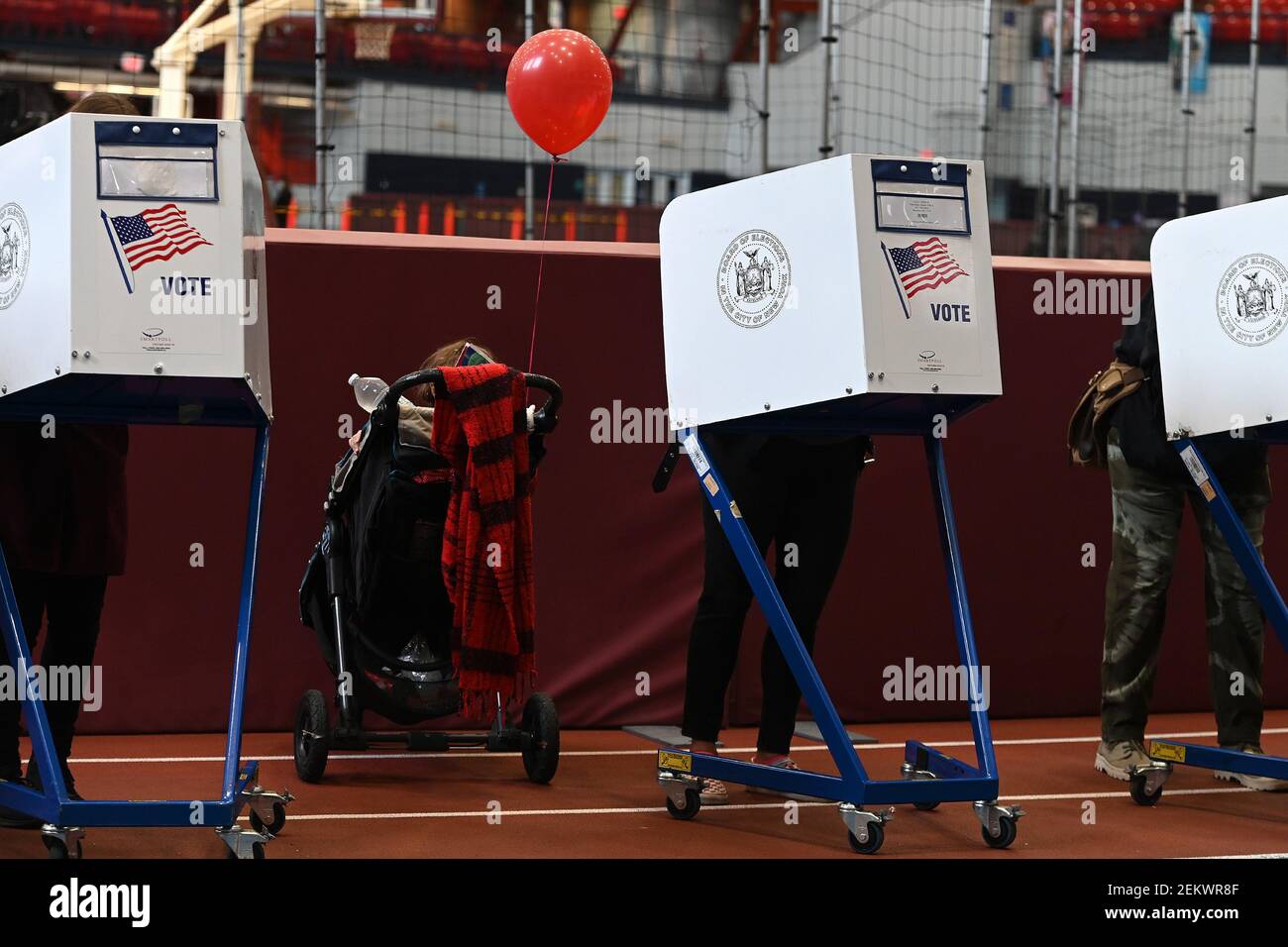 A child sits in stroller parked next to her parent as they as they fill ...
