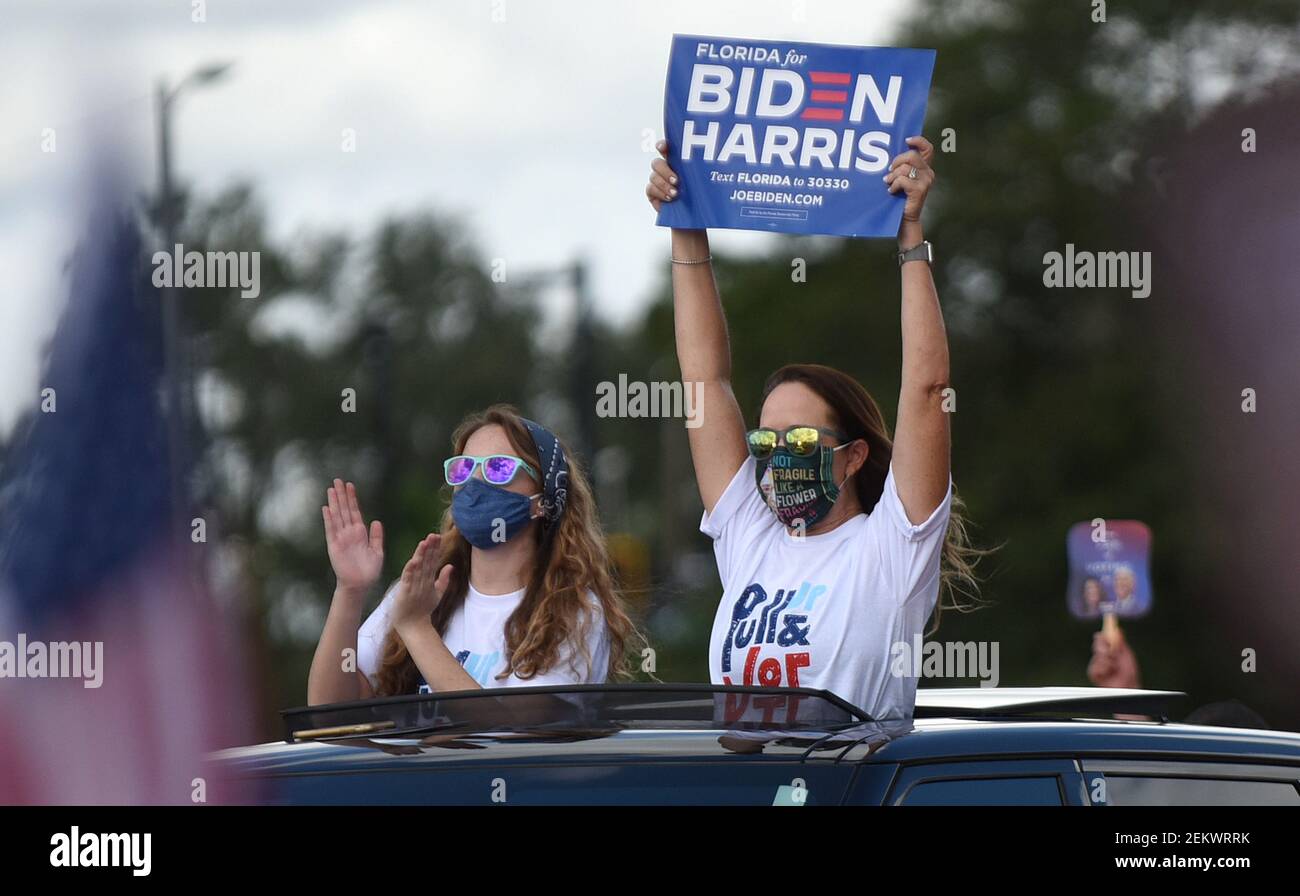 A supporter holding a placard standing in an open roof vehicle during ...