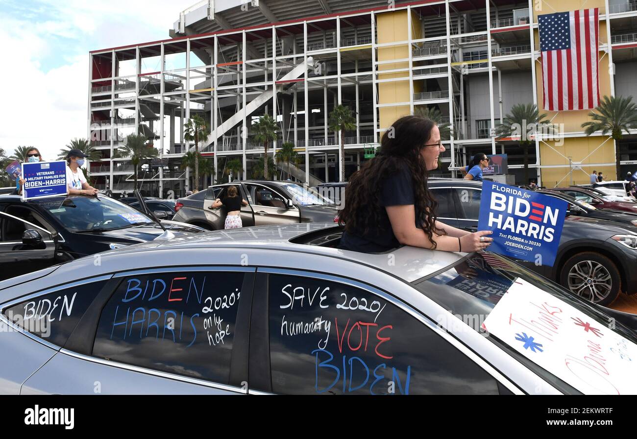 A supporter holding a placard standing in an open roof vehicle during ...
