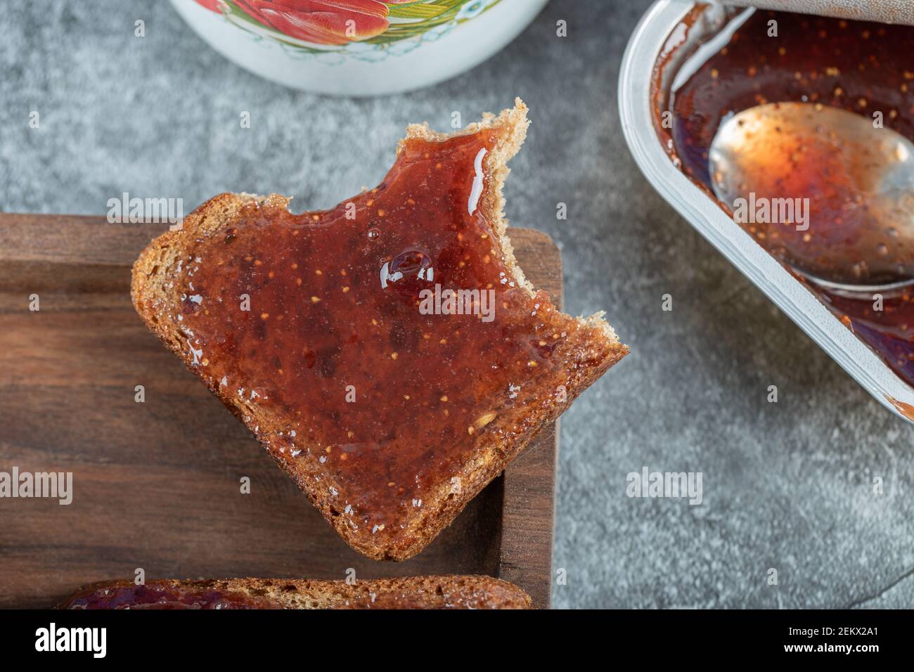 Strawberry jam with slice of brown bread and cup of tea Stock Photo - Alamy