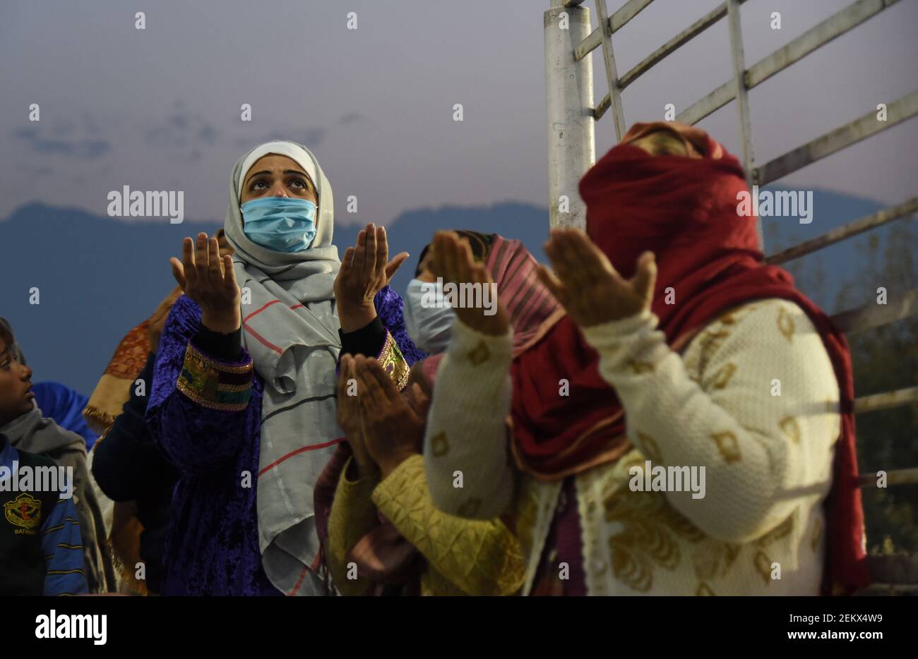 Kashmiri Muslim devotees raise their hands while beseeching for ...