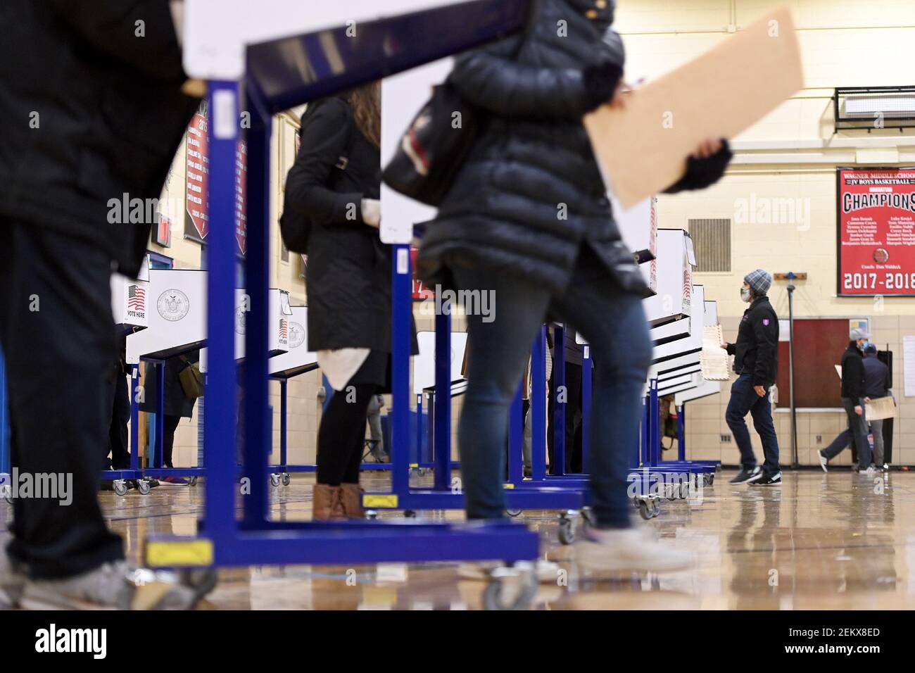 People stand behind a voter privacy booth to fill out ballots during ...