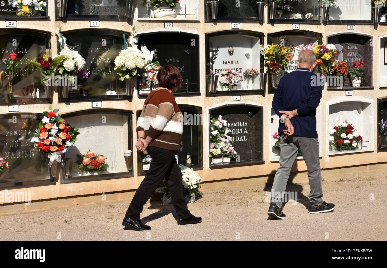 A couple visiting the grave of a relative in the cemetery during All ...