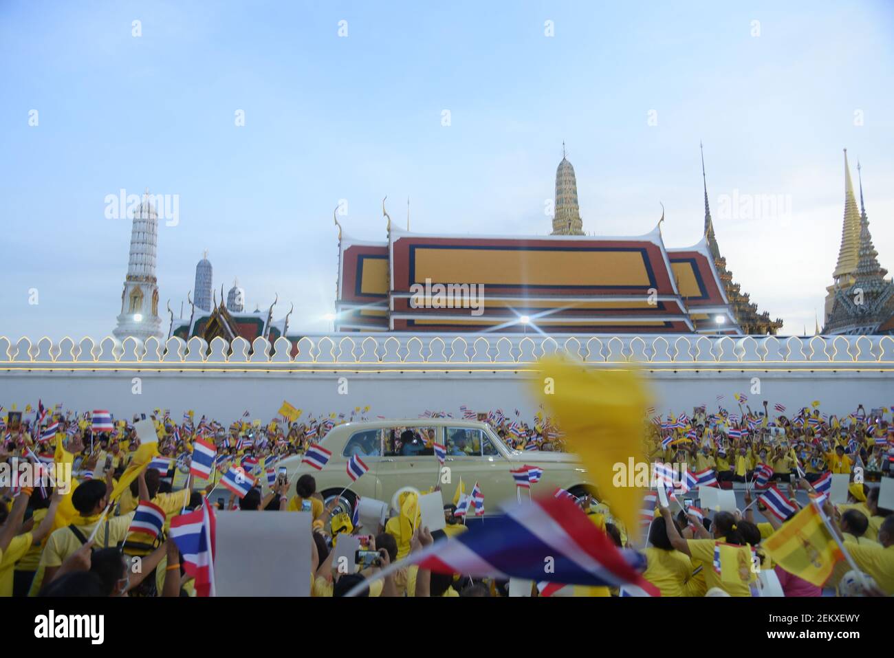People wave flags as the Thai King Maha Vajiralongkorn and Queen ...