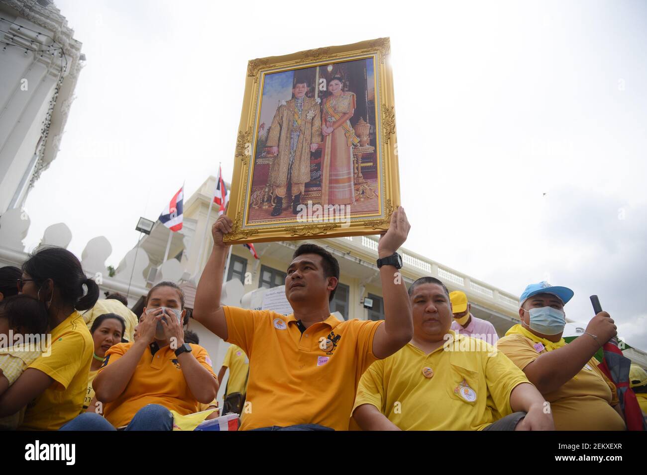 A man holds a picture of the Thai King Maha Vajiralongkorn and Queen ...