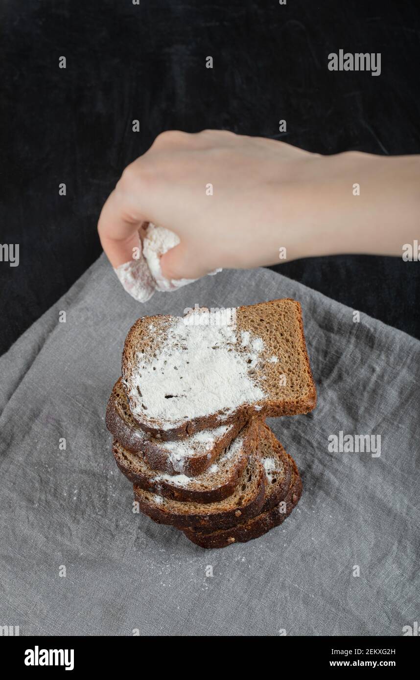 Woman hand adds flour into black bread slices Stock Photo - Alamy