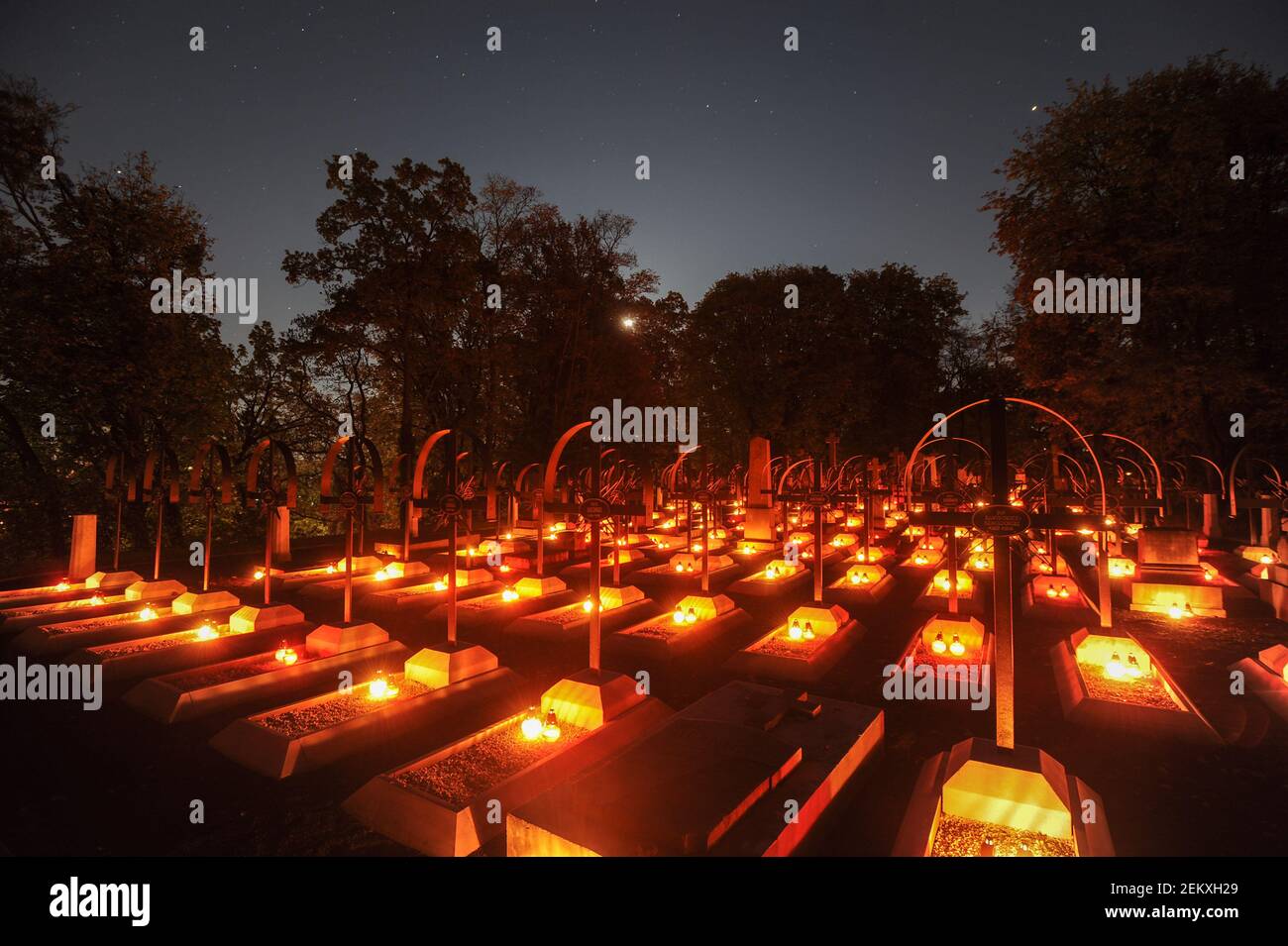 Burning candles on different graves in the cemetery during All Saints ...