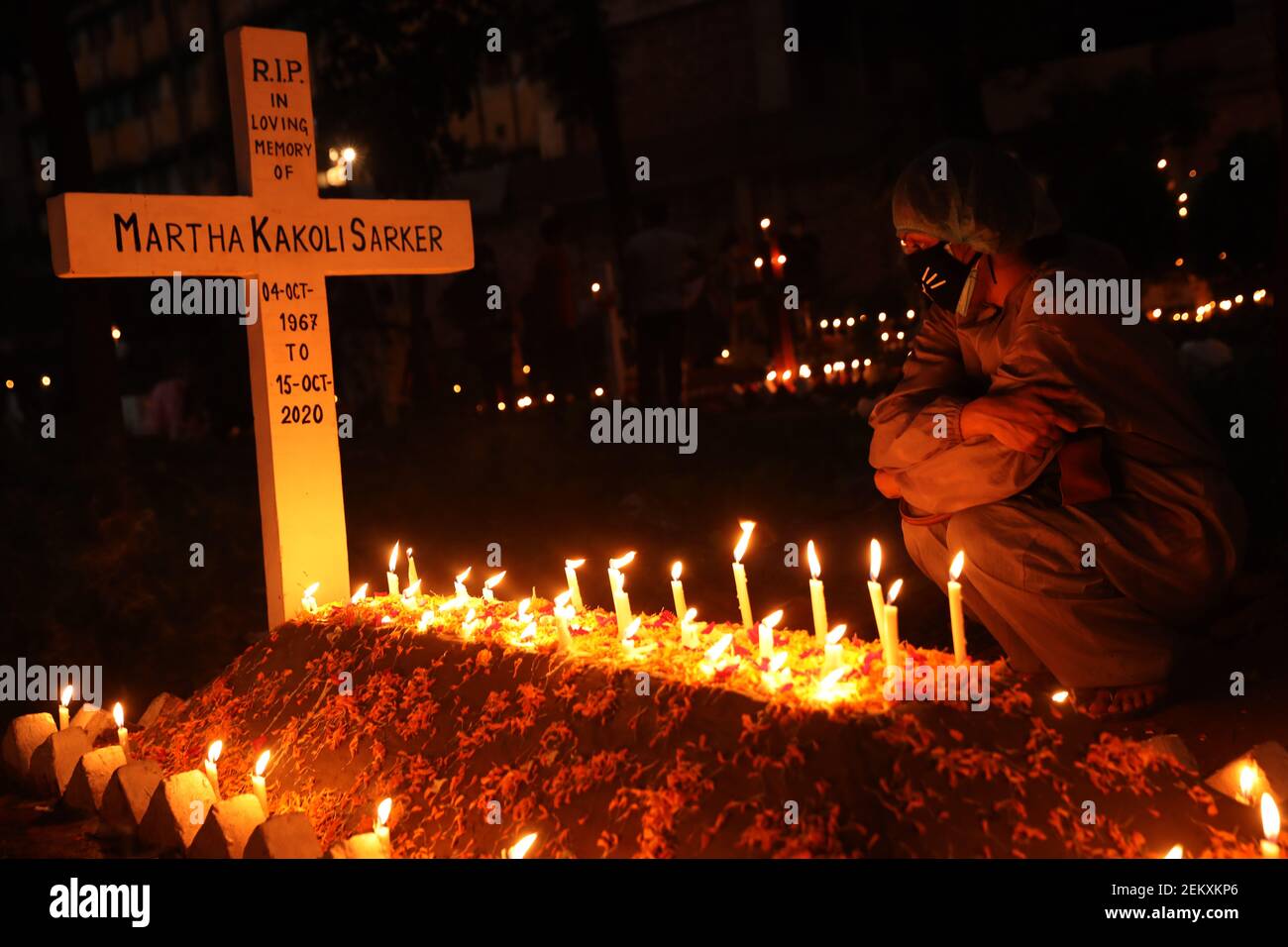 A catholic family member offers prayers for the dead at a Dhaka ...