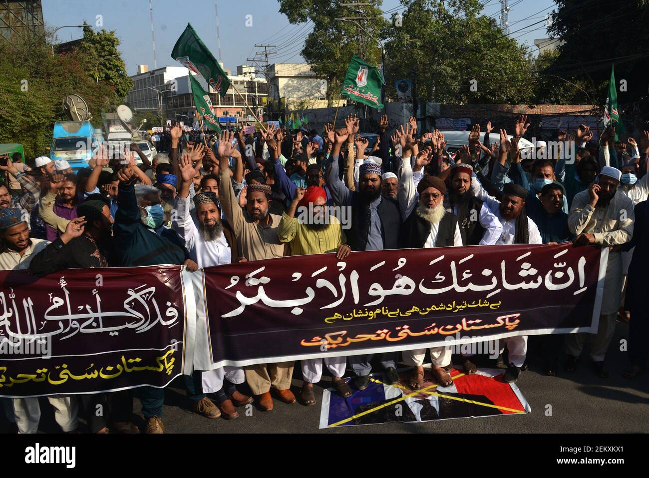 Pakistani supporters of Sunni Tehreek, a religious group, hold banner ...