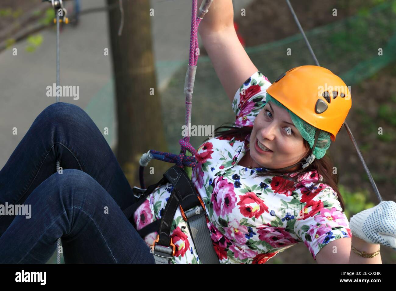 Woman climber hanging on a rope in the adventure park Stock Photo - Alamy