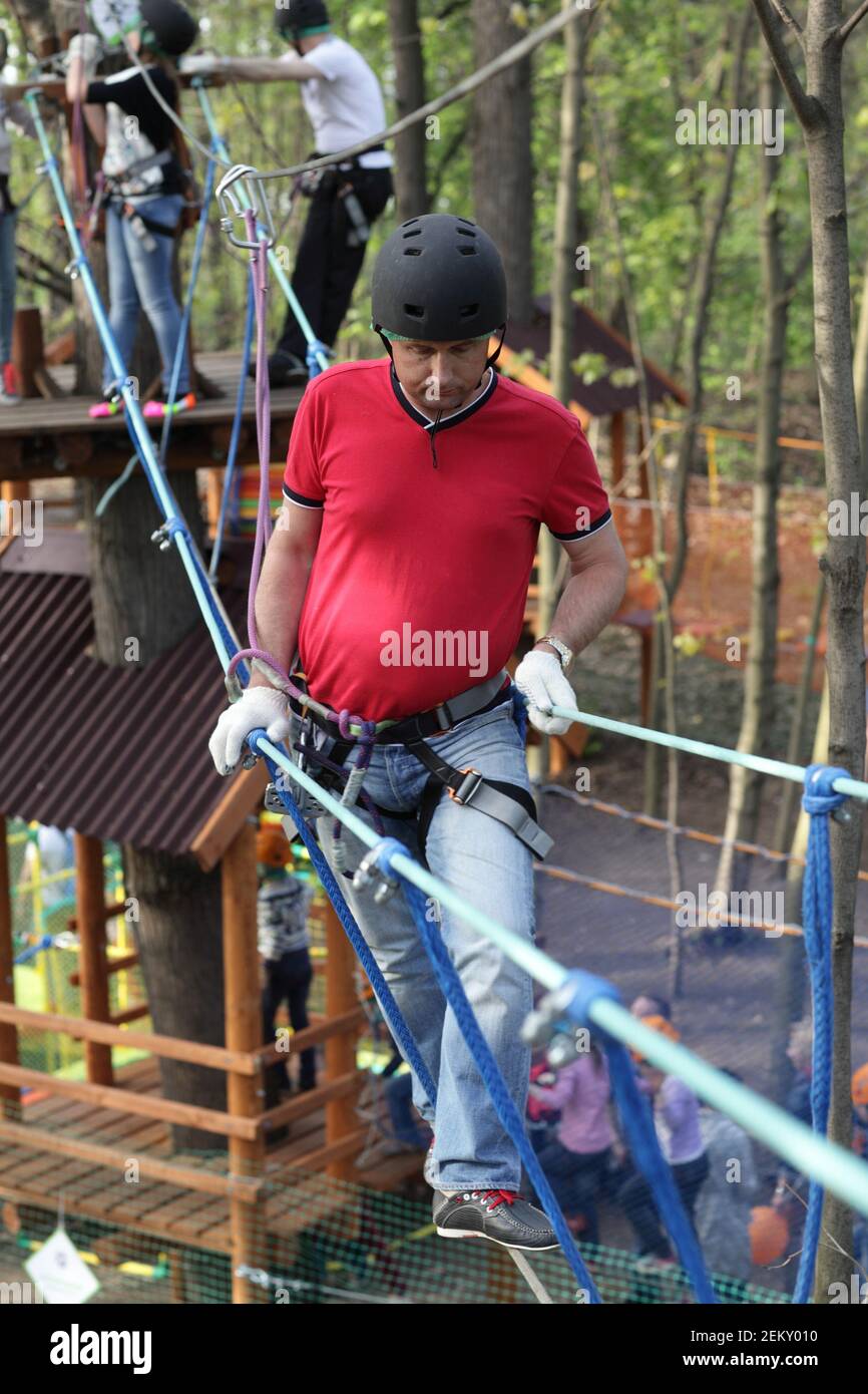 Man climbing in adventure park in summer Stock Photo - Alamy