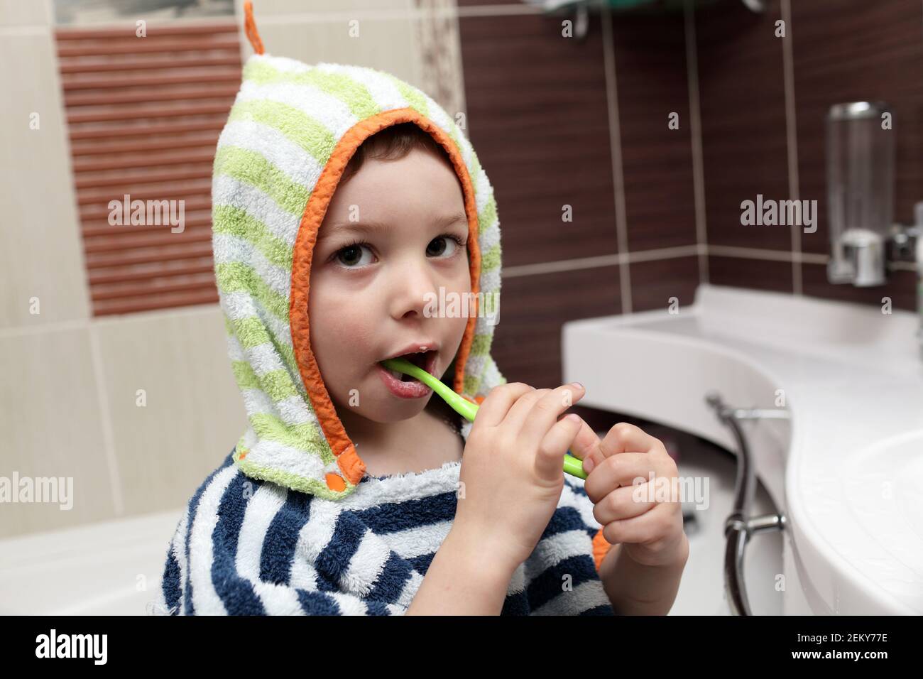 Kid brushing his teeth in the bathroom Stock Photo - Alamy