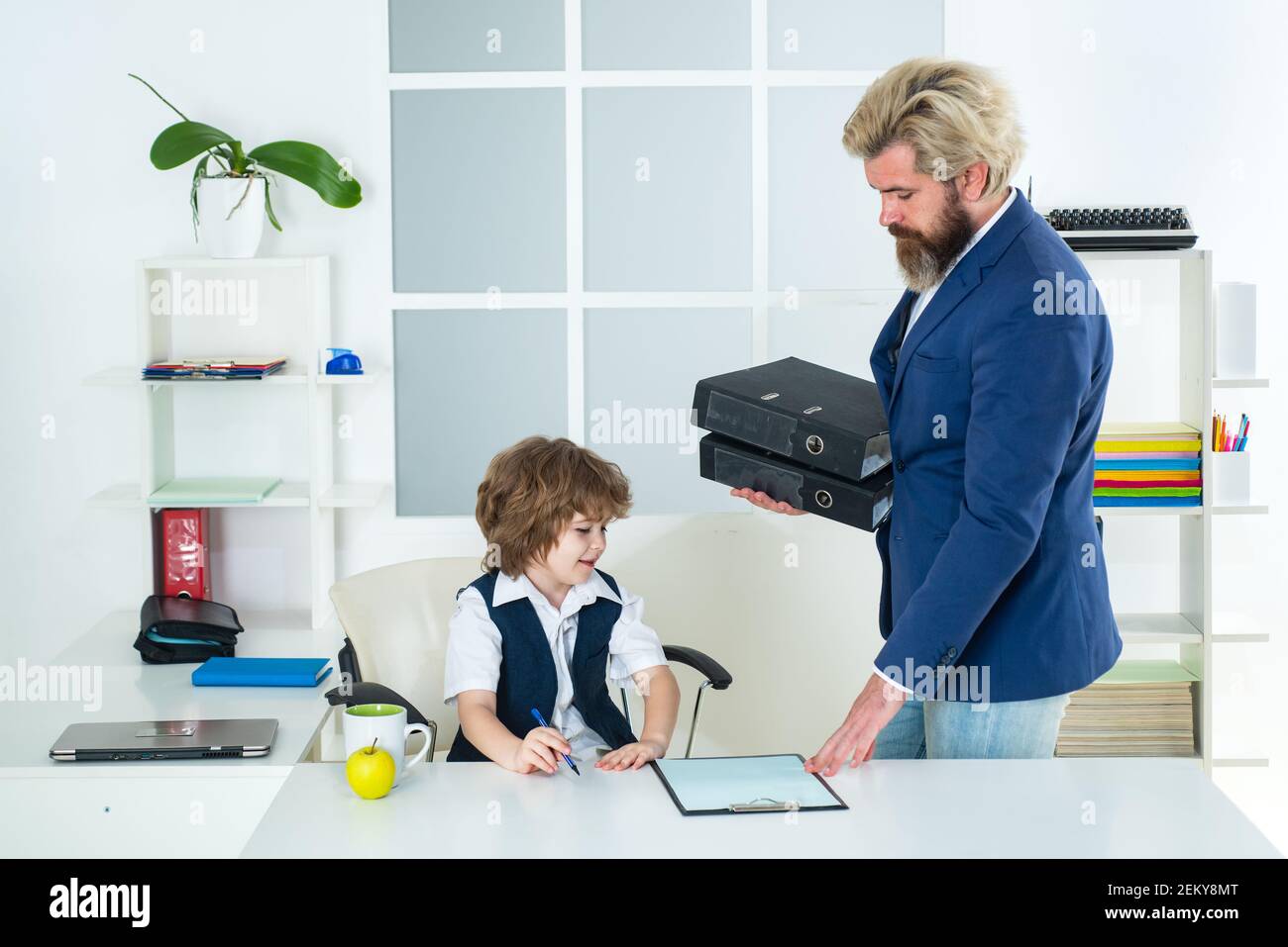 Businessman father with his son drawing on business papers at office ...