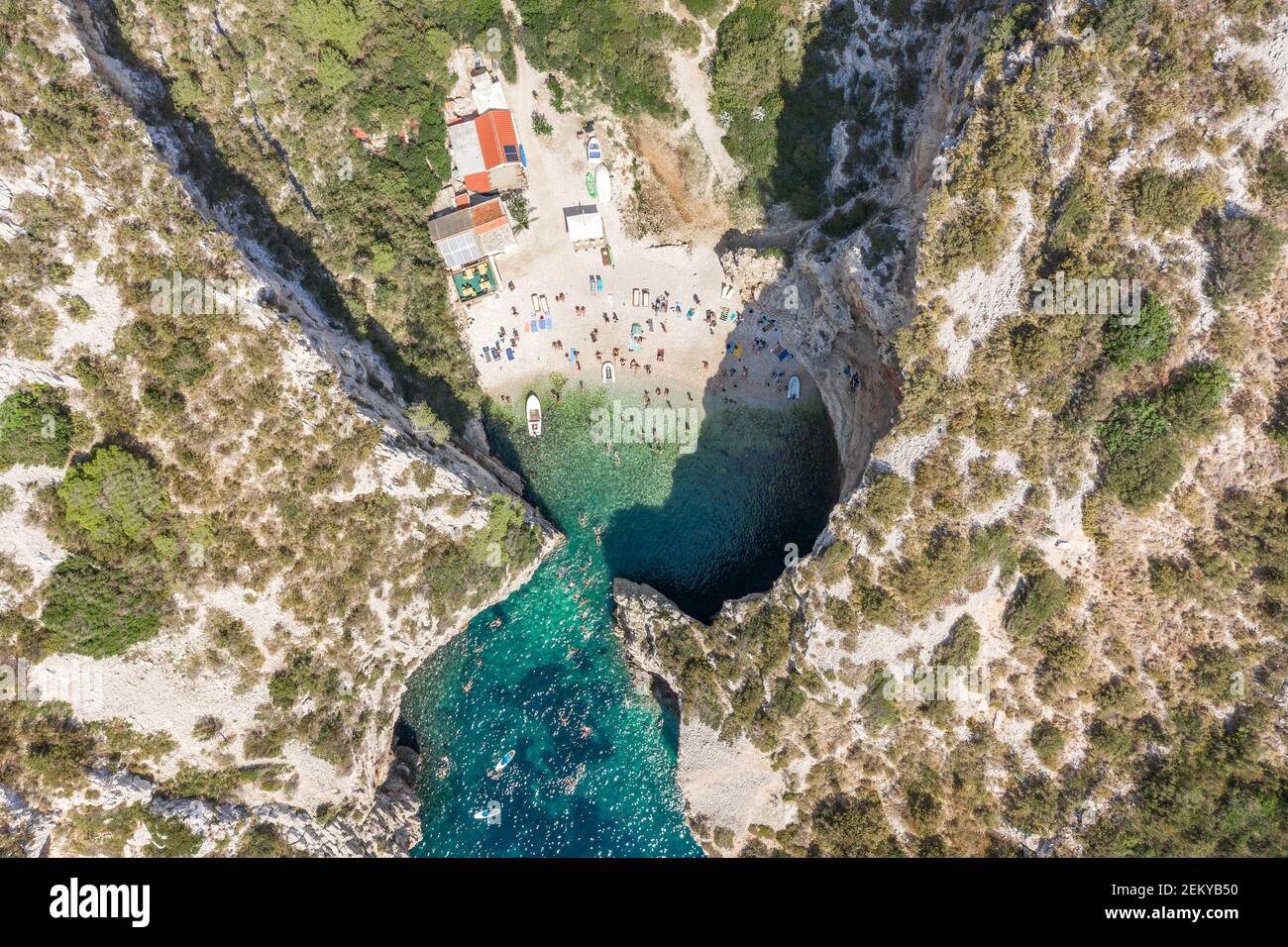 Aerial overhead drone shot of tourists swim sunbath at Stiniva beach on ...
