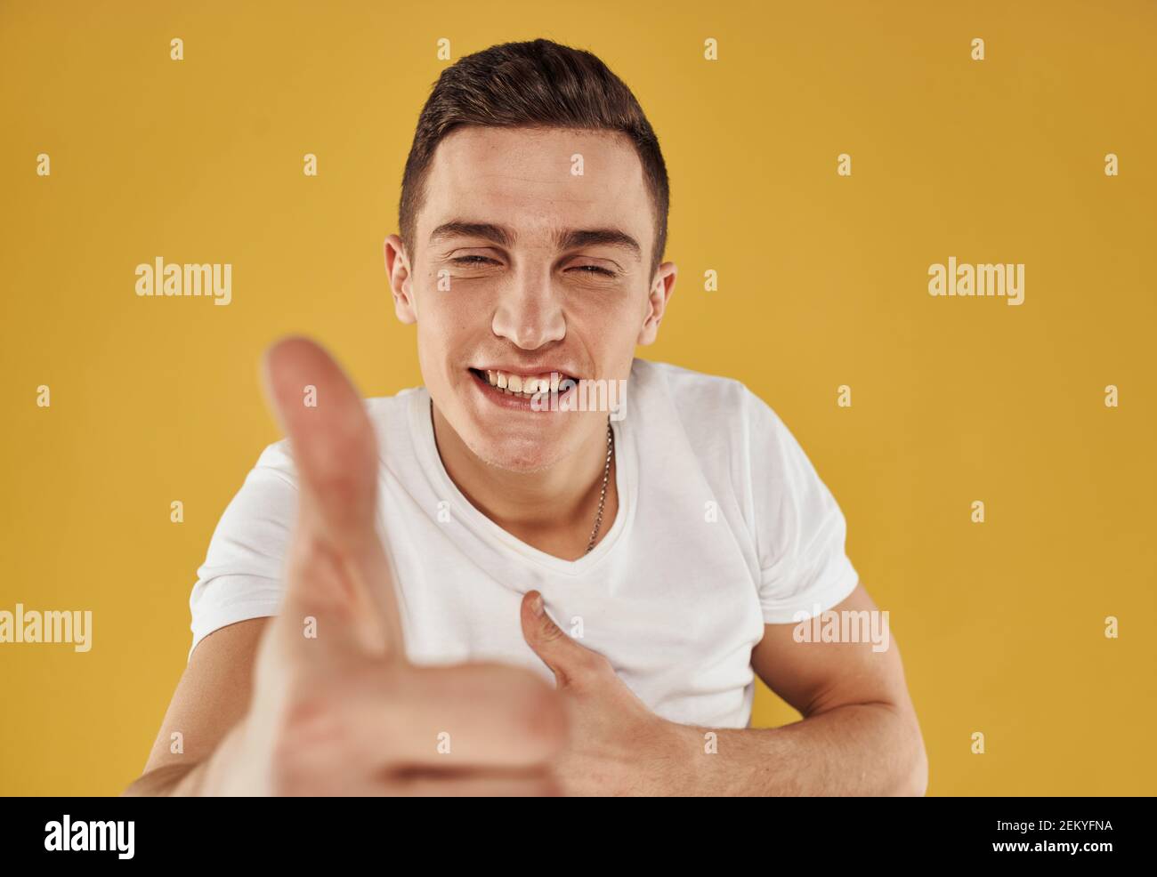 happy brunette man on yellow background shows positive hand gesture Stock Photo - Alamy
