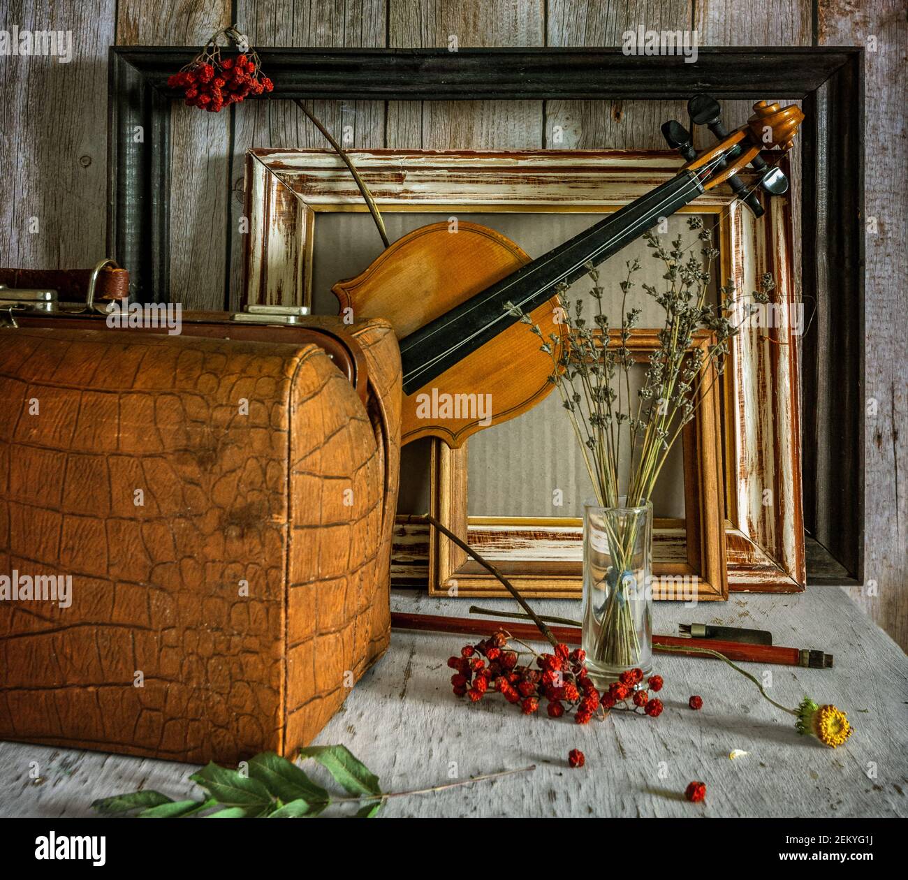 Still life with old things. Burnt-out ancient travel bag. Violin with ...