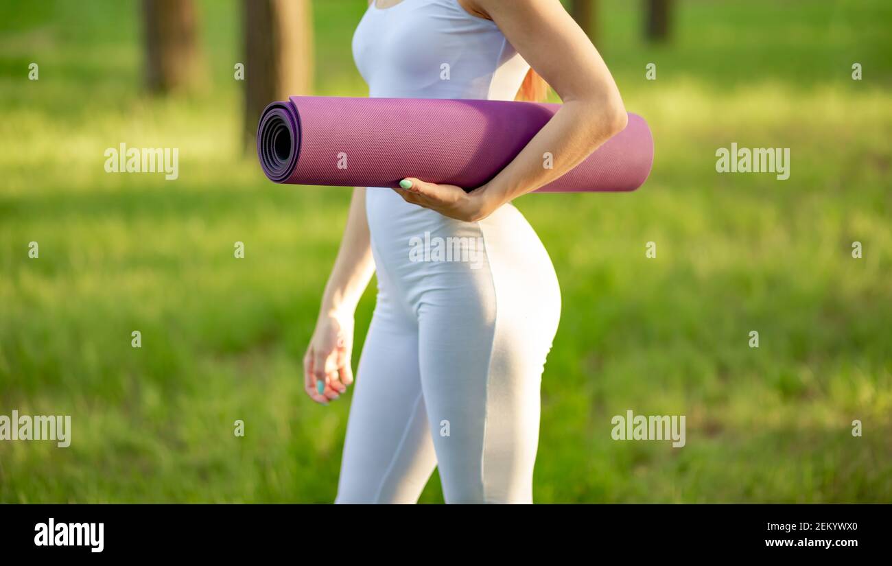 Woman rolling yoga mat in hi-res stock photography and images - Alamy