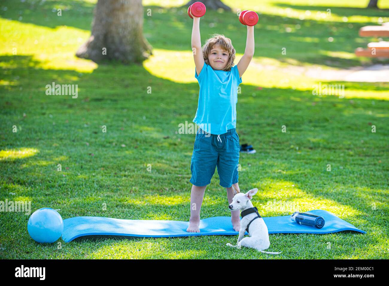 Sporty lifestyle concept. Sport yoga child with dumbbell and dog. Boy ...