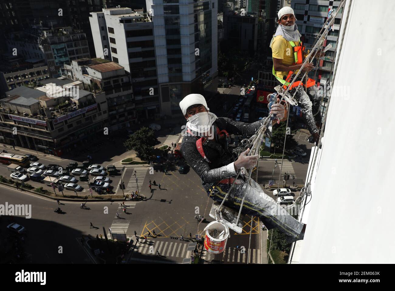 Workers paint a high-rise building on a construction site at Gulshan ...