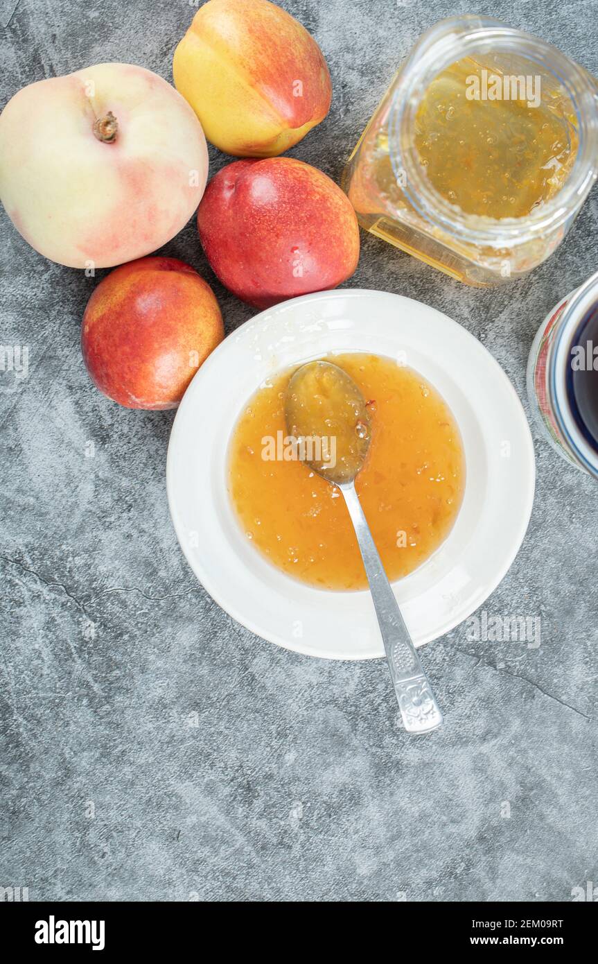 Peaches, jam and cup of tea on marble table Stock Photo - Alamy