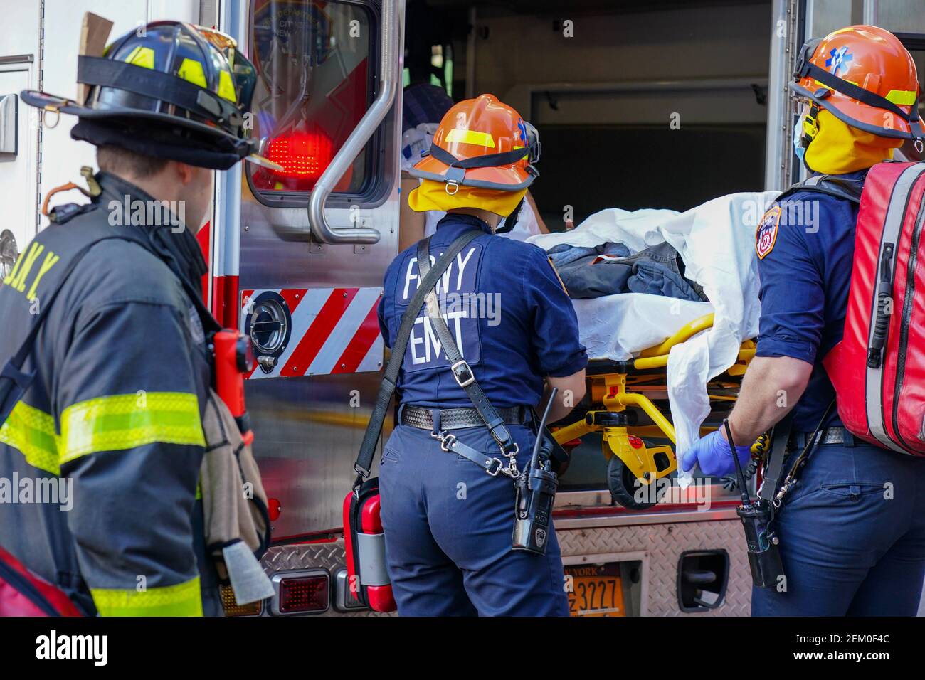 An injured construction worker being brought by an ambulance. A ...