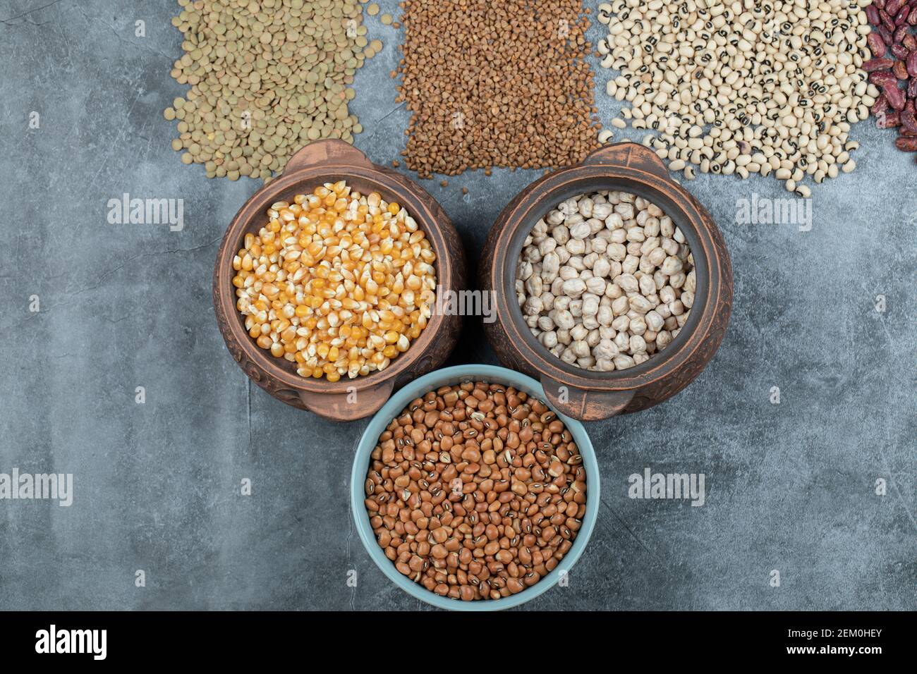 Different kinds of raw beans on a gray background Stock Photo - Alamy