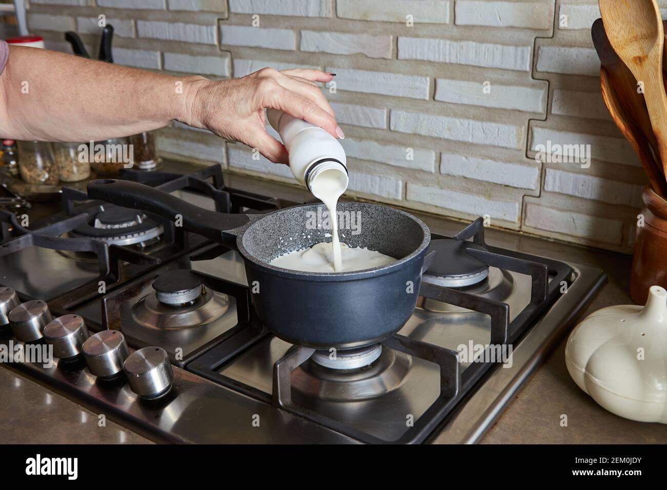 Chef pours cream saucepan cooking hi-res stock photography and images ...