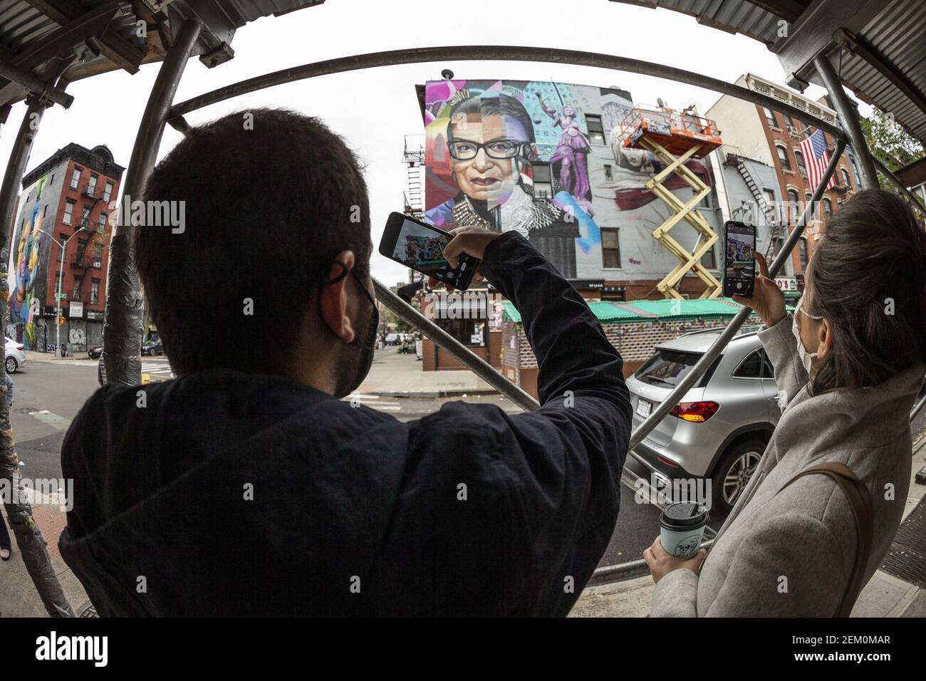 People taking photos as ELLE street art working on mural Notorious RBG ...